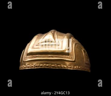 old gold antique Indian helmet from South America on a black background ...