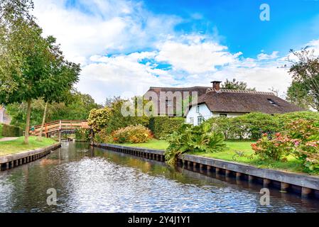 Traditional Dutch thatched-roof cottages on the canal in the village of ...