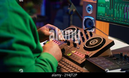 Audio engineer with headset mixing and mastering his recorded files ...