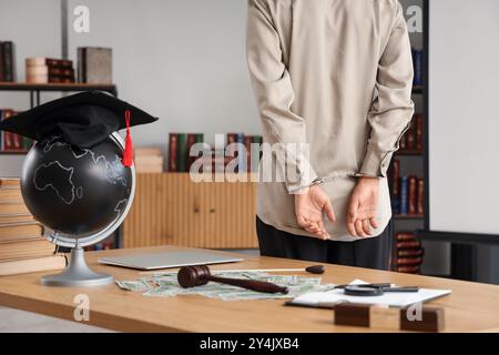 Handcuffed male teacher in classroom, back view. Corruption concept ...