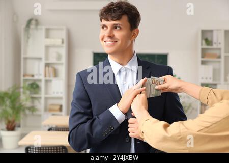 Female teacher taking bribe in classroom, closeup. Corruption concept ...