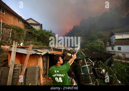 Villager try to extinguish a wildfire as it approaches the village in ...
