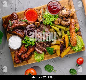 Top view of a delicious bbq feast with dips on a wooden board ...