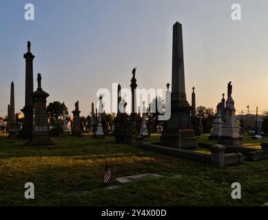 The sun rises behind grave markers in Cathedral Cemetery in West ...