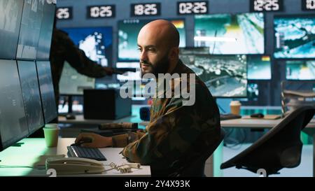 Man looking at screens in military HQ base housing operational missile ...