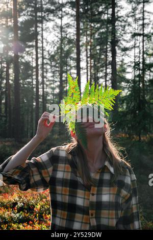 A human hand holds a green and yellow health insurance card. A ...