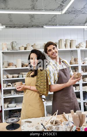 A young couple enjoys a playful pottery session while exchanging smiles ...