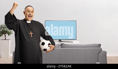Happy priest football supporter holding a ball and cheering isolated on ...