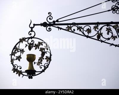 Wrought iron shop sign with wine glass and vines Stock Photo - Alamy