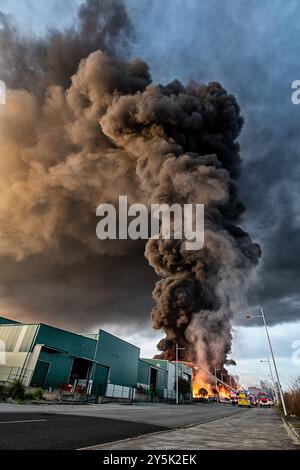 A big column of smoke rises for a fire in an industrial estate Stock ...