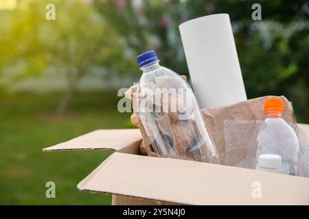 Recycling. Different garbage in cardboard box outdoors Stock Photo - Alamy