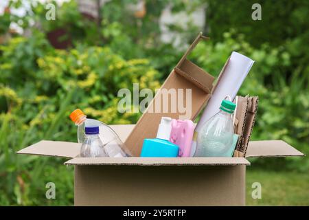 Recycling. Different garbage in cardboard box outdoors Stock Photo - Alamy