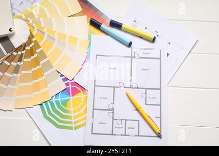 Designer's workplace with color palettes, floor plan and pen on white ...