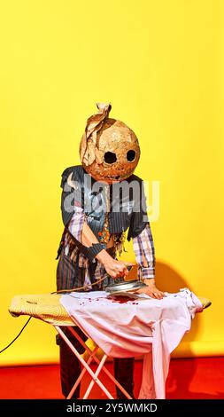 Terrifying character in ripped clothes and creepy mask, standing with ...