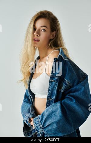 Blonde woman displays her chic denim look inside a fashion studio ...