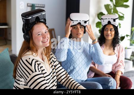 Using VR headsets, diverse women friends enjoying virtual reality ...