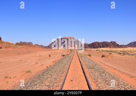 Old train rails almost completely covered with desert sand in Wadi Rum ...