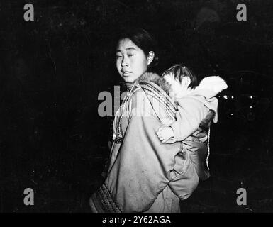 Inuit woman with her baby in traditional Amauti dress in North Americas ...
