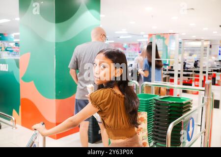 Asian girl entering an entrance gate of modern supermarket Stock Photo ...