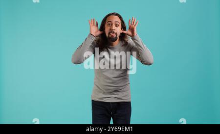 Portrait of spiteful man making exaggerated silly faces, mimicking ...