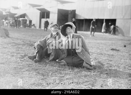 Mrs. Payne Whitney with unidentified gentleman seated on flying field ...