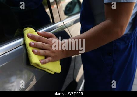 Man wiping car door with yellow rag, closeup Stock Photo - Alamy