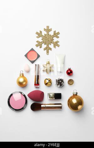 Christmas tree made of balls and makeup cosmetics on red background ...