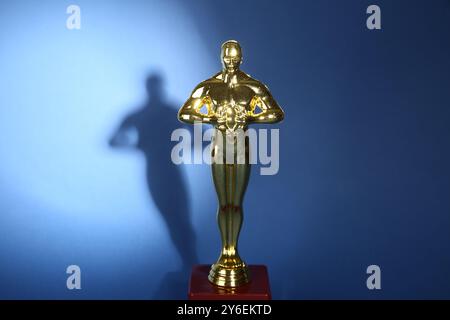 One golden Oscar award on red background Stock Photo - Alamy