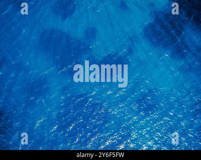 An aerial view of the azure water of the ocean and a green island in ...