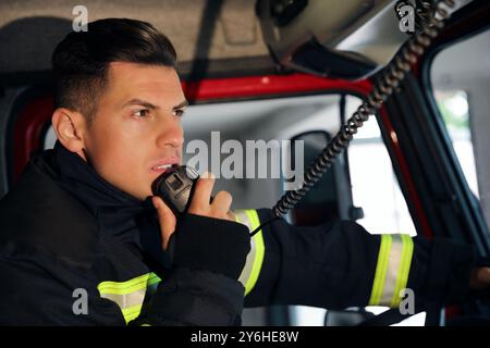 Firefighter using radio set while driving fire truck Stock Photo - Alamy
