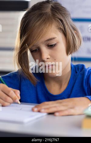 Schoolboy writing in notepad Stock Photo - Alamy