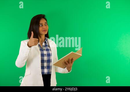 Asian woman doctor reading book resting on couch with laptop computer ...