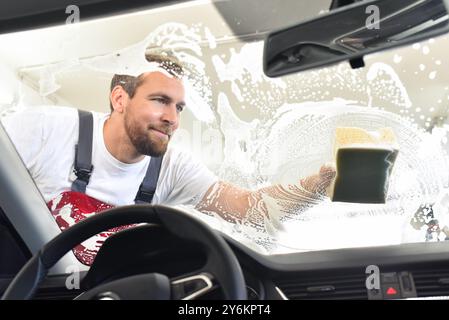 friendly mechanic cleans a car professionel in the car dealership for ...