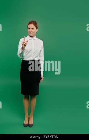 A poised TV presenter stands against a bright green backdrop Stock ...