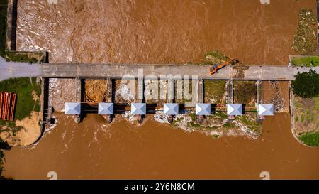 Aerial view of the dam's floodgates with rapid flow of water in the ...