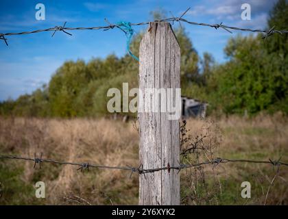 A barbed wire fence stands out against a blue sky in Berlin, June 19 ...