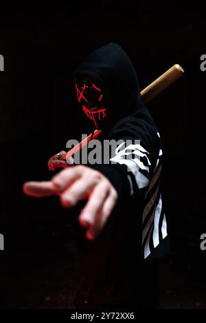 A creepy masked character of the purge anarchy with a baseball bat ...