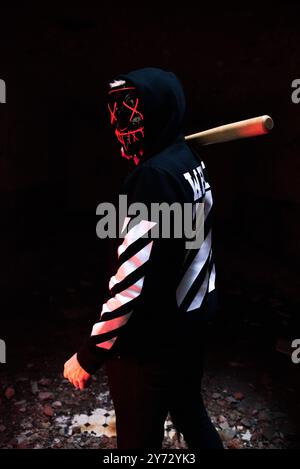 A creepy masked character of the purge anarchy with a baseball bat ...