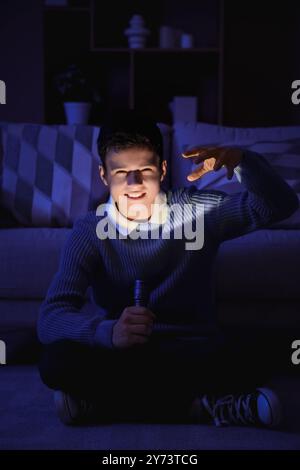 Teenage boy with shining flashlight on beige background Stock Photo - Alamy