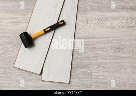 Mallet and laminate boards on floor. Construction industry Stock Photo ...