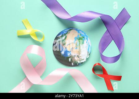 Different awareness ribbons on turquoise background. World Cancer Day ...