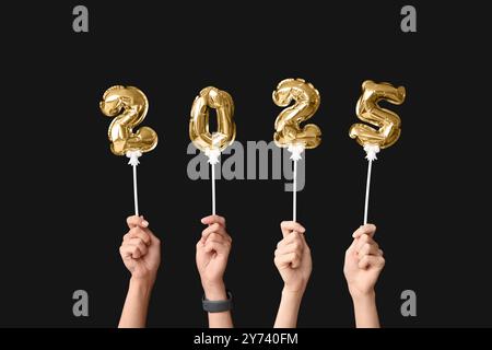 Female hands with figure 2025 made of foil balloons, gift box, shoes ...