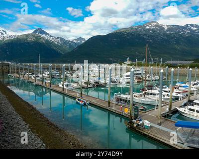 The boat docks at Skagway, Alaska, in the shadow of a snowy glacial ...