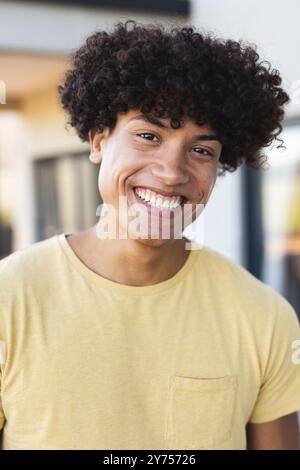 Smiling young man in a yellow sweathsirt greeting with cap isolated on ...