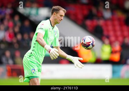 Colchester United goalkeeper Matt Macey (right) punches clear from ...