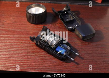 Image of an opened flashlight with old round batteries covered with ...