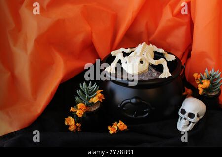 Frog skeleton escaping from witch's cauldron. Halloween decoration ...