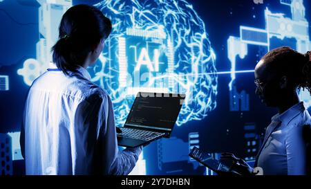 IT team members programming scripts on computer, employing AI machine learning. Software ...