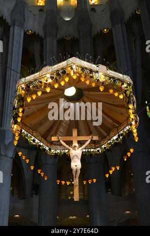 Crucified Jesus Christ statue above altar in the Sagrada Familia basilica in Barcelona ...