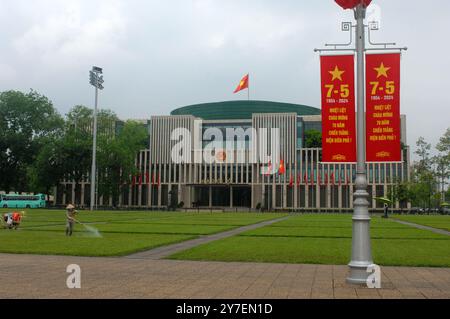Female gardeners maintaining the lawns outside the Viet Nam National Assembly Building, Hanoi ...